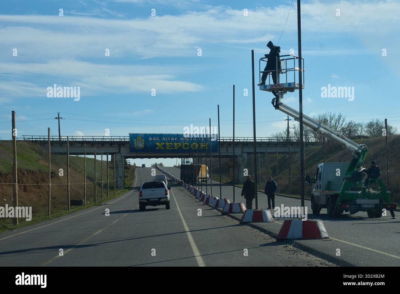Municipal workers install an anti-FPV-drone net above the road at the ...