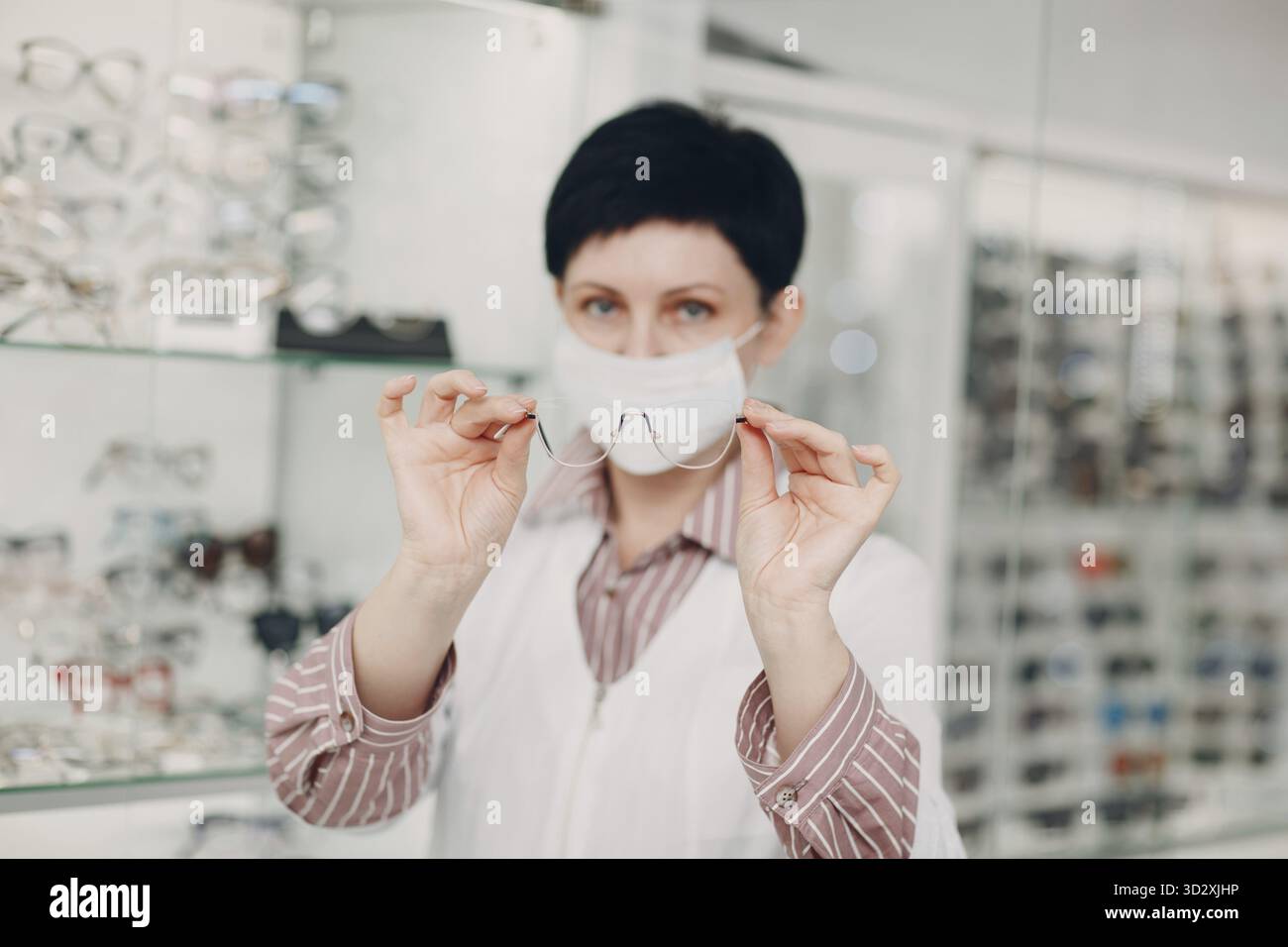 Happy Optician in Medical Face Mask Choosing Eyeglasses, female ...