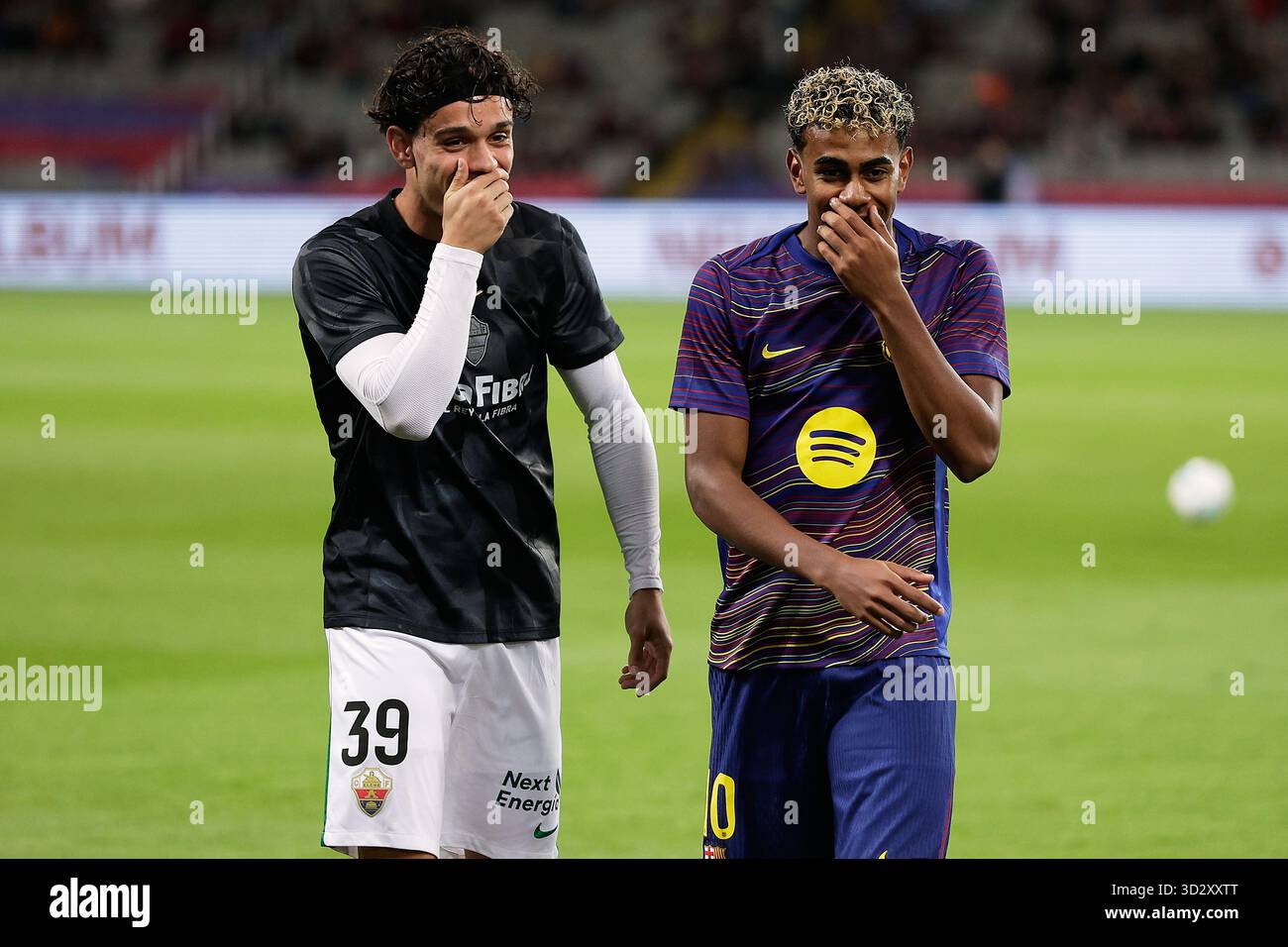 Lamine Yamal of FC Barcelona with Hector Fort of Elche CF during the ...