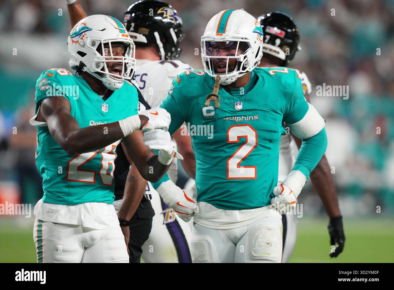 Miami Dolphins running back De'Von Achane (28) stands with linebacker ...