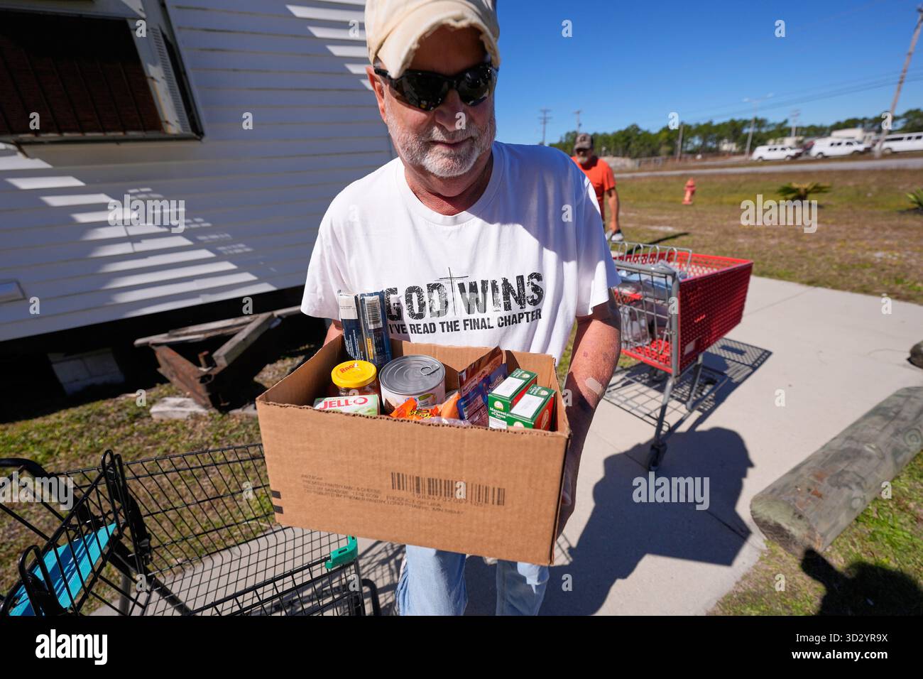 Volunteer Mike Bohlke hands food donations to recipients at the Long ...
