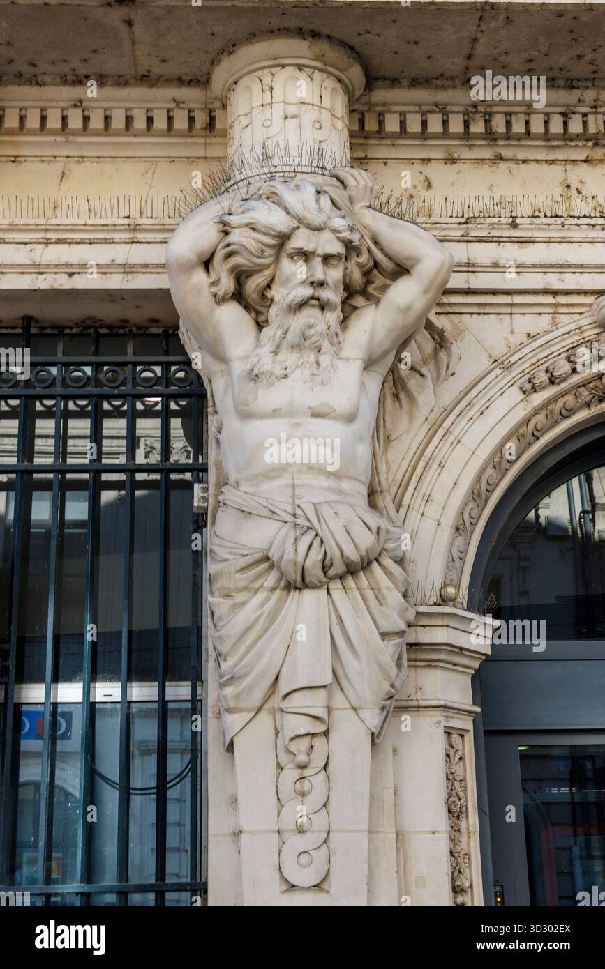 Statue on building of man holding up pillar, Saumer, France Stock Photo ...