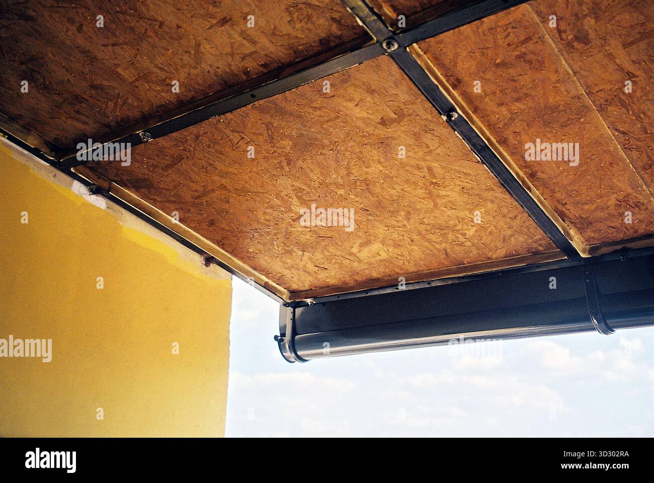 OSB panels mounted on a metal frame forming a terrace canopy, captured ...