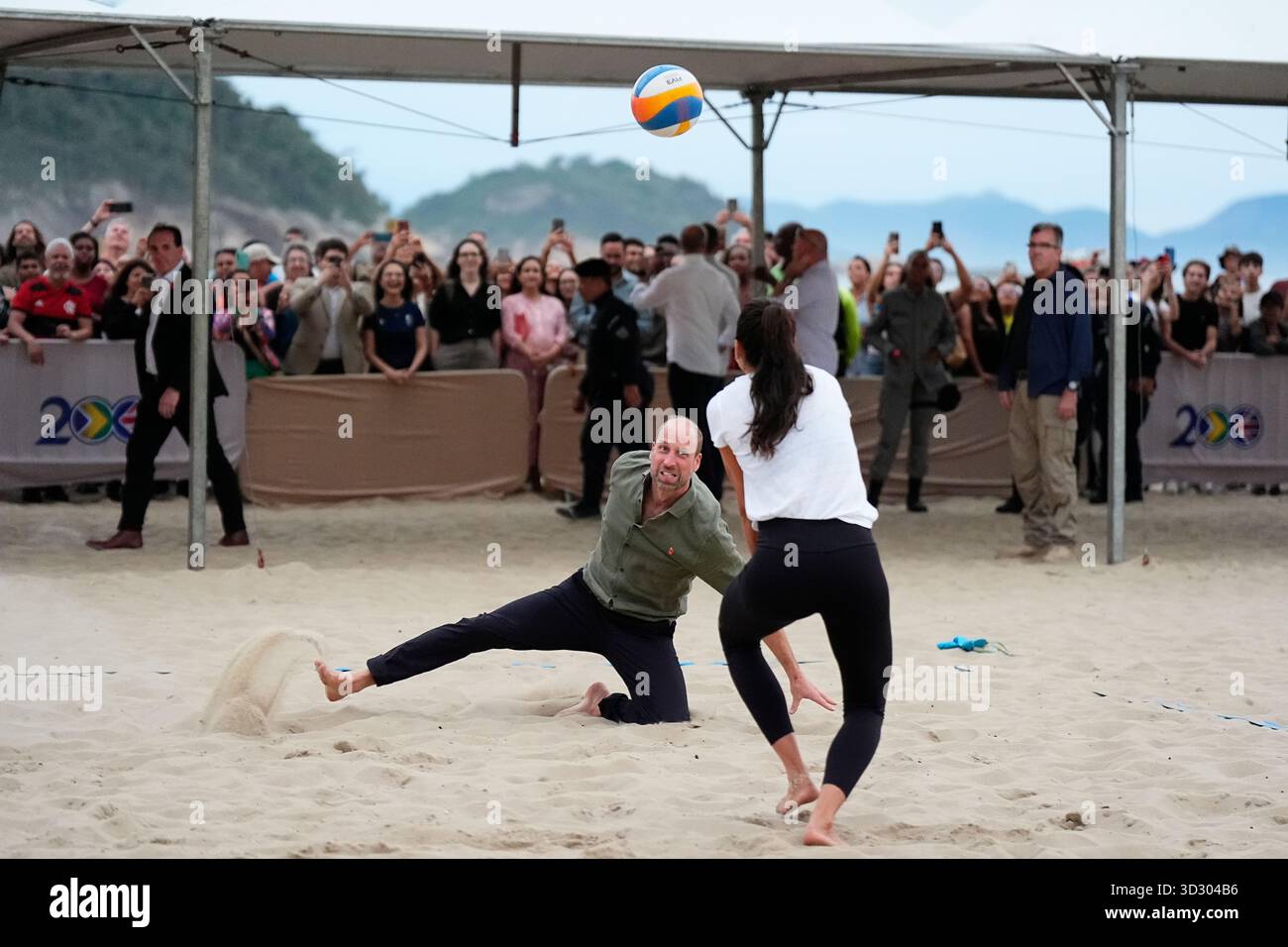 The Prince of Wales takes part in a game of volleyball with players ...