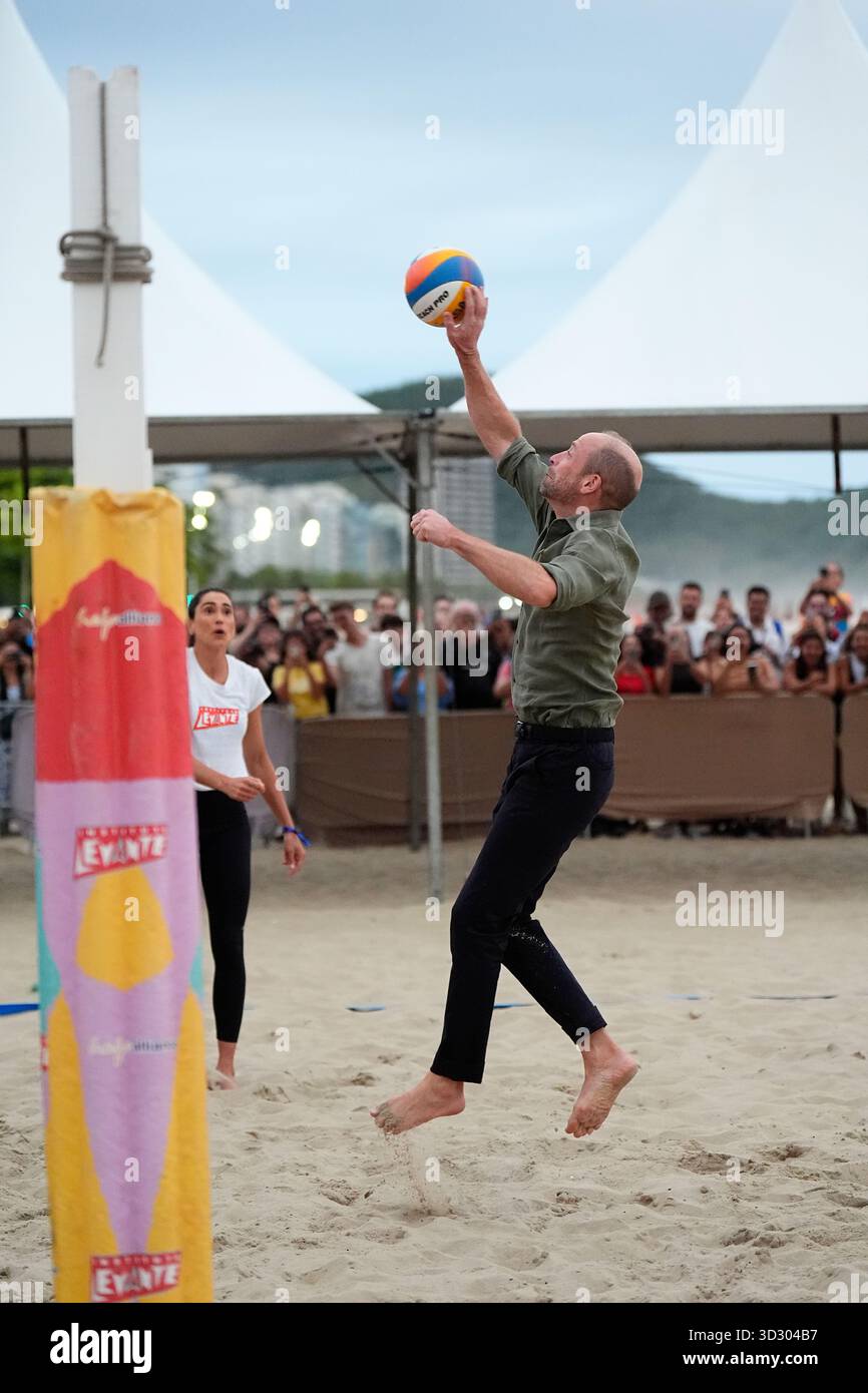 The Prince of Wales takes part in a game of volleyball with players ...