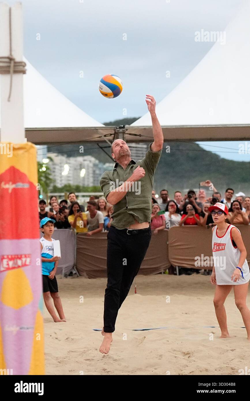 The Prince of Wales takes part in a game of volleyball with players ...
