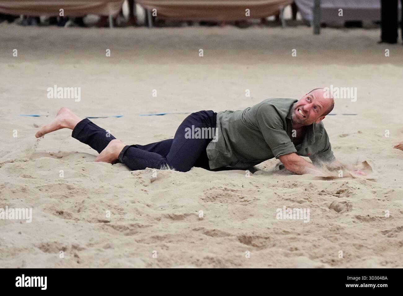 The Prince of Wales takes part in a game of volleyball with players ...