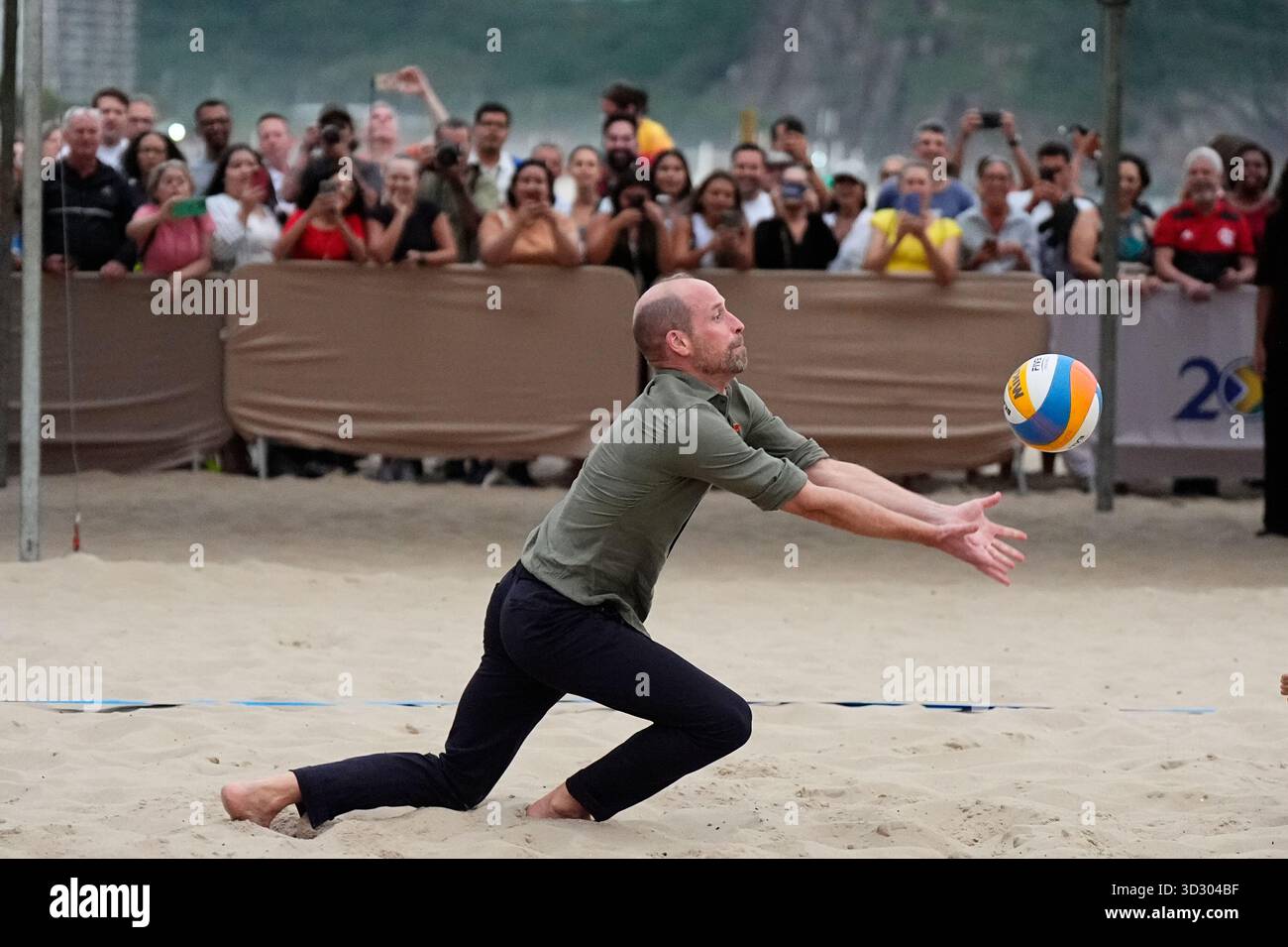 The Prince of Wales takes part in a game of volleyball with players ...