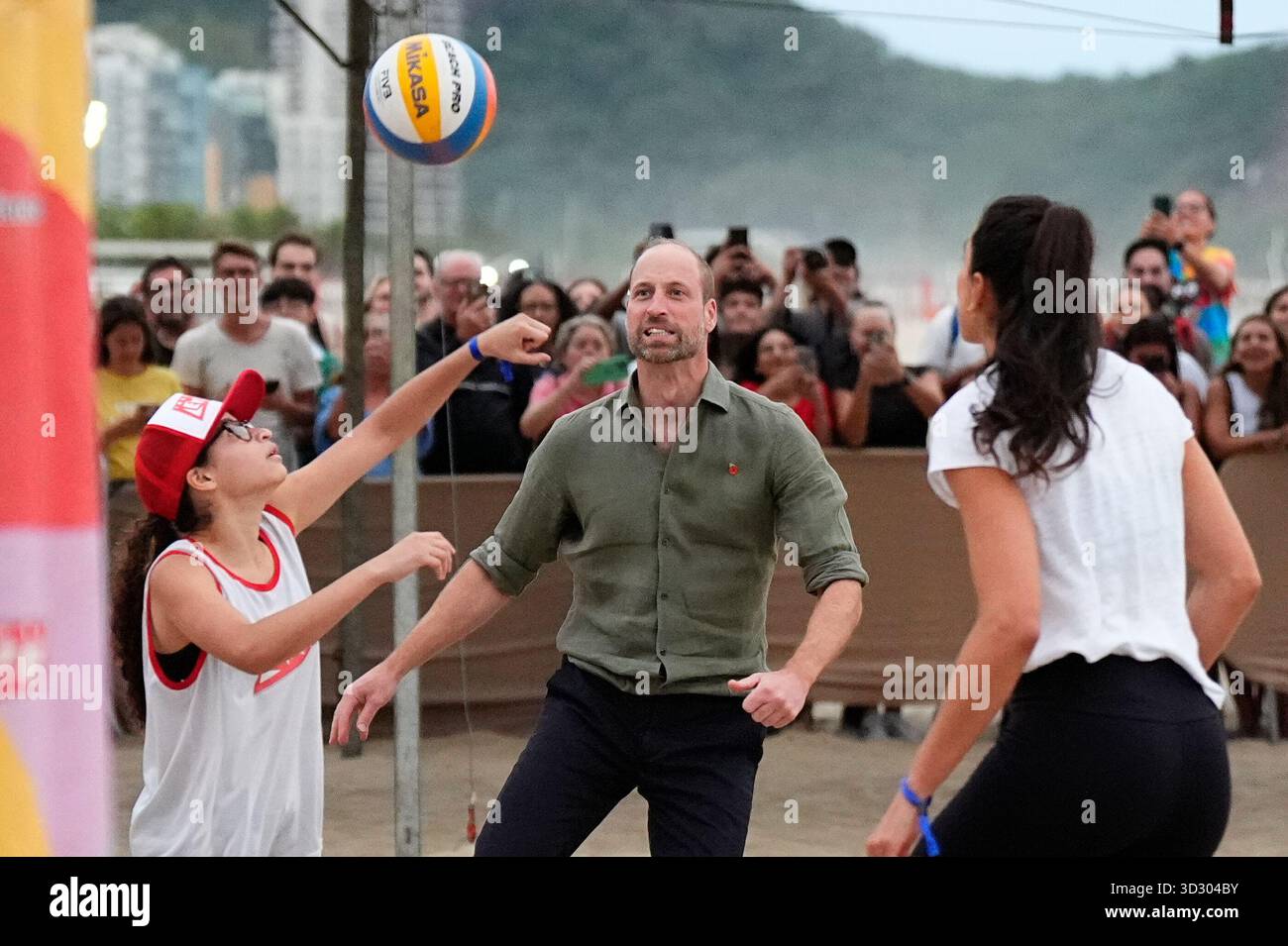 The Prince of Wales takes part in a game of volleyball with players ...