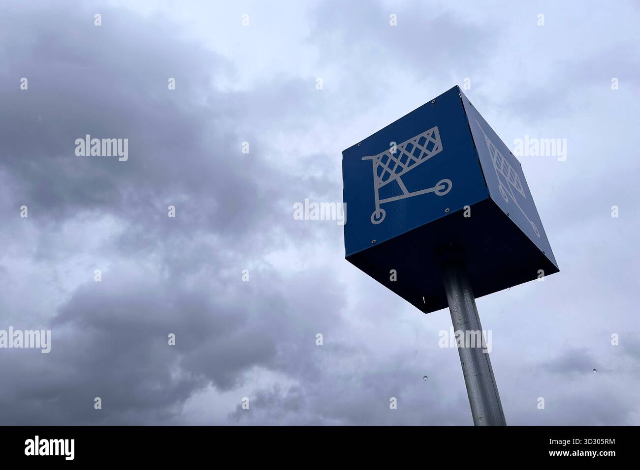 A grocery cart sign stands in the parking lot of a Walmart is rained on ...