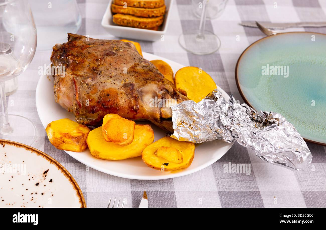 Traditional Spanish lunch is served - fried baked leg of lamb with side ...