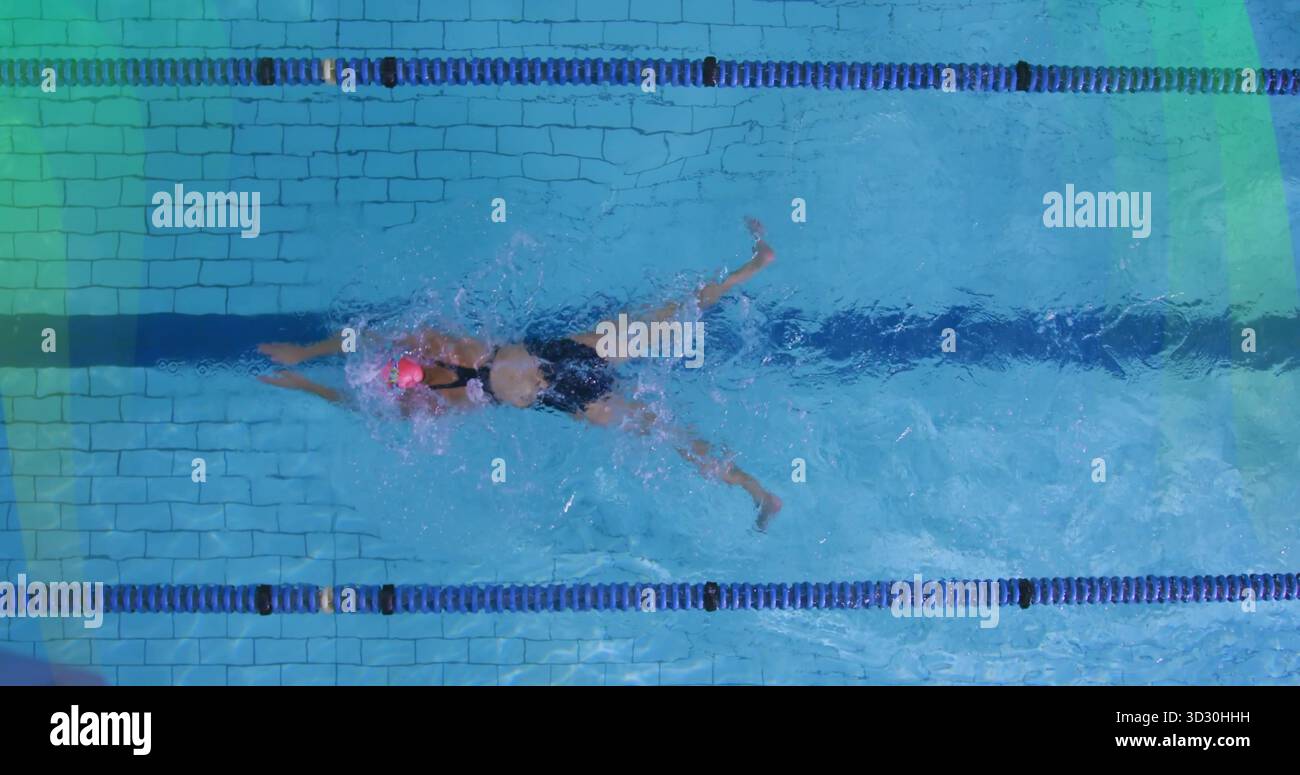 Gliding swimmer wearing one-piece swimsuit and pink cap through lap ...