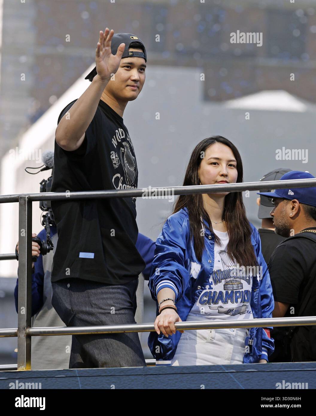 Los Angeles Dodgers two-way player Shohei Ohtani and his wife Mamiko ride on an open-top bus ...
