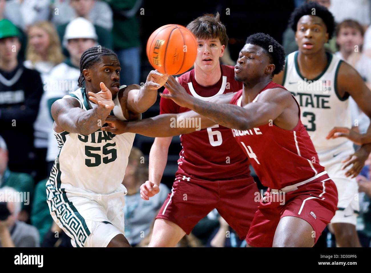 Michigan State forward Coen Carr (55) passes the ball against pressure ...