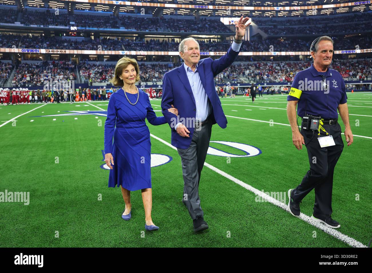 Former president George W. Bush and Laura, left, walk onto the field ...