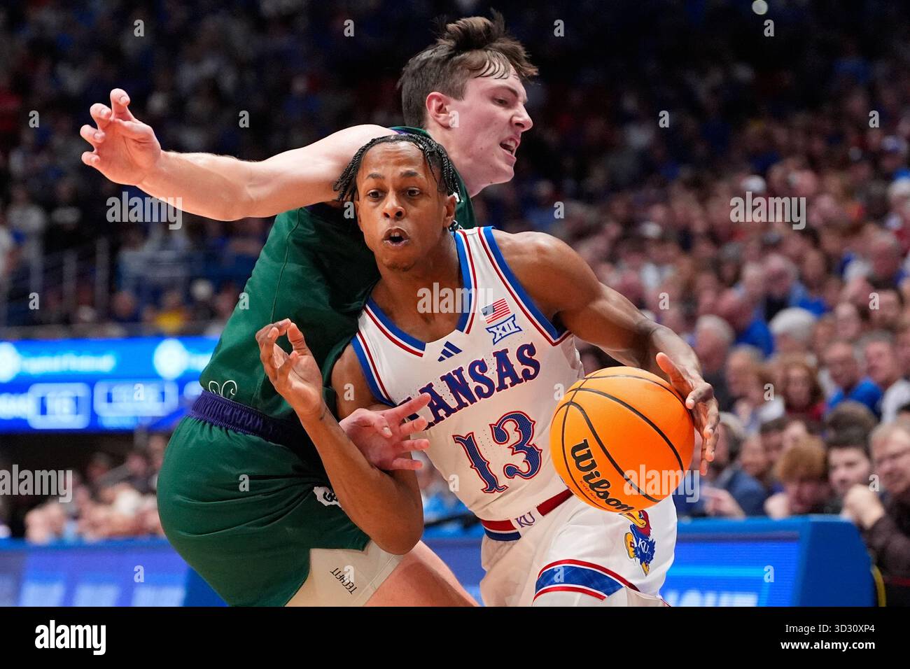 Kansas guard Elmarko Jackson (13) drives past Green Bay forward Marcus ...