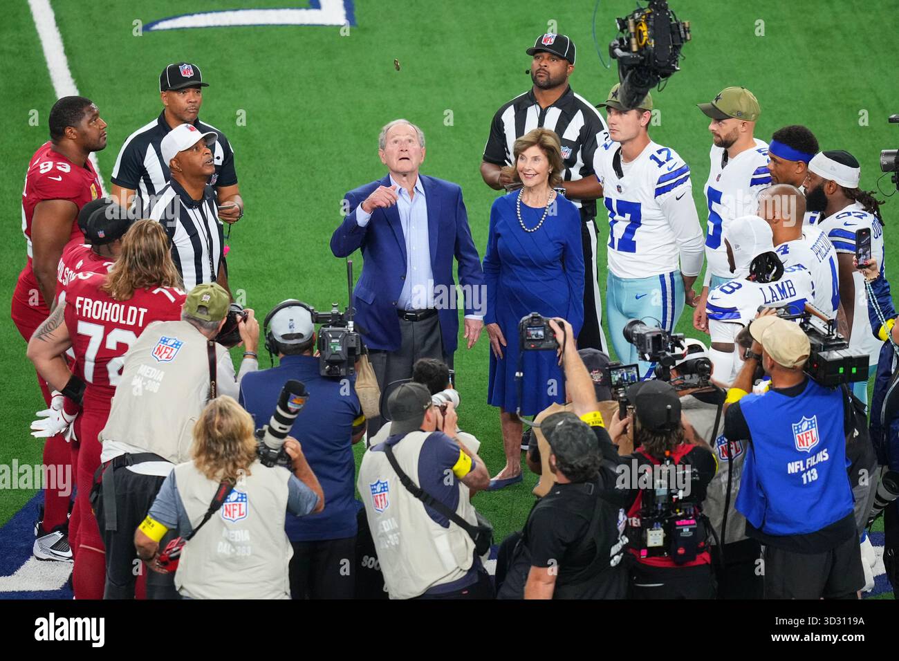 Former president George W. Bush, flips the coin as Laura, officials, the Arizona Cardinals and ...
