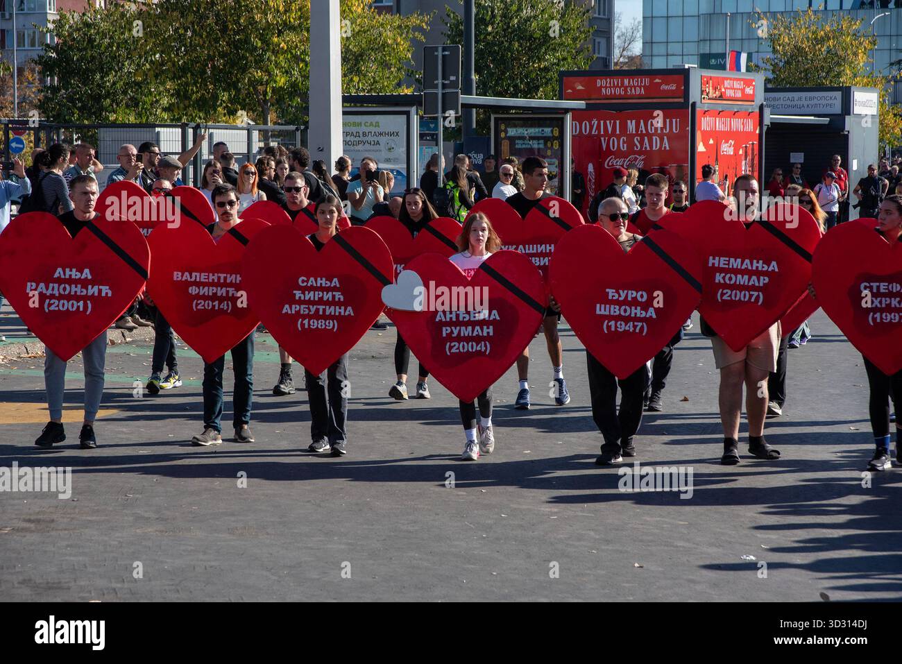 Students carry large red hearts for the memories of the victims outside ...
