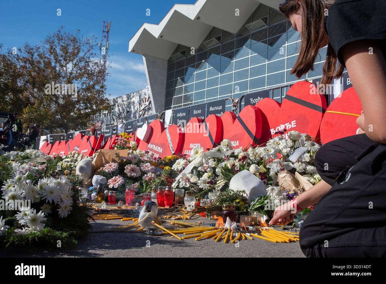 A mourner lights a candle up during the commemoration ceremony outside ...