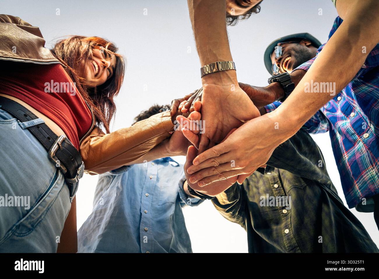 A low-angle view of a happy, multicultural group of young friends ...