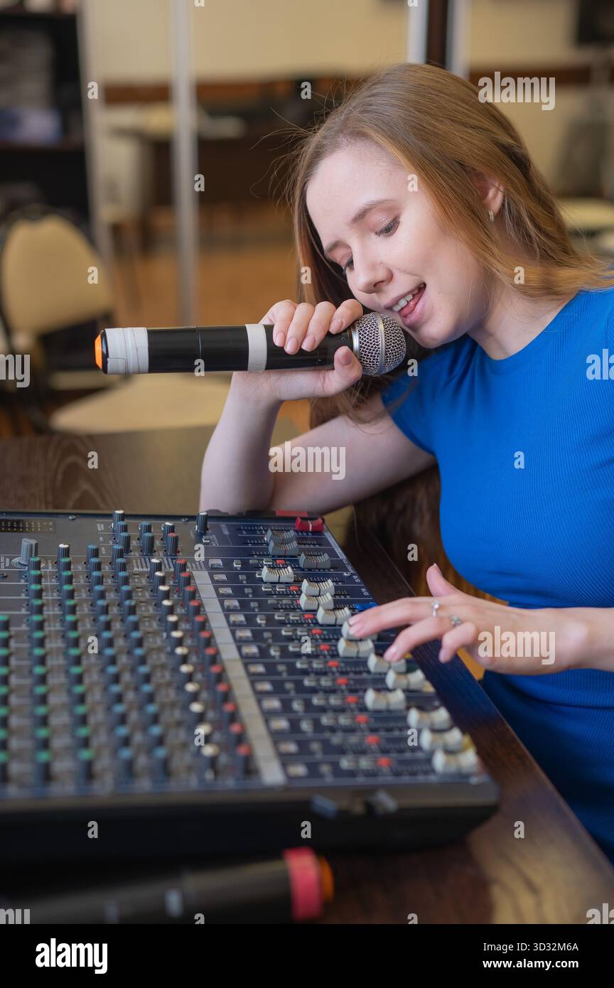Young woman mixing live sound. Girl recording a song in the studio ...