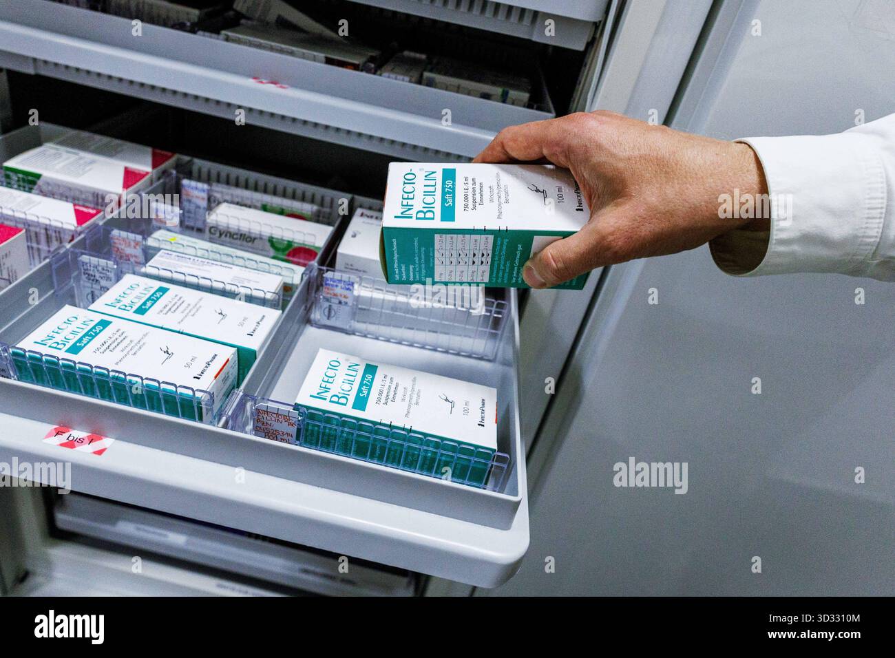 29 September 2025, Berlin: A pharmacist takes the antibiotic InfectoBicillin from a drawer in ...