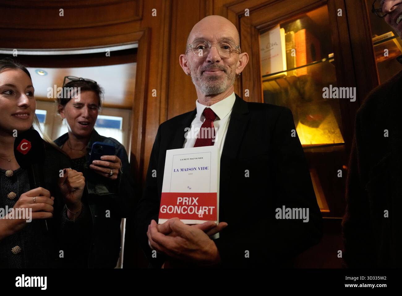French novelist Laurent Mauvignier holds his book "La Maison Vide" (The ...