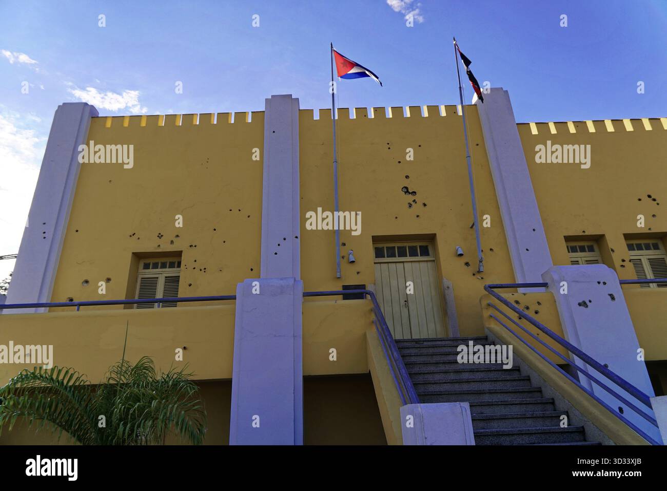 Santiago de Cuba, yellow building with raised flags and visible ...