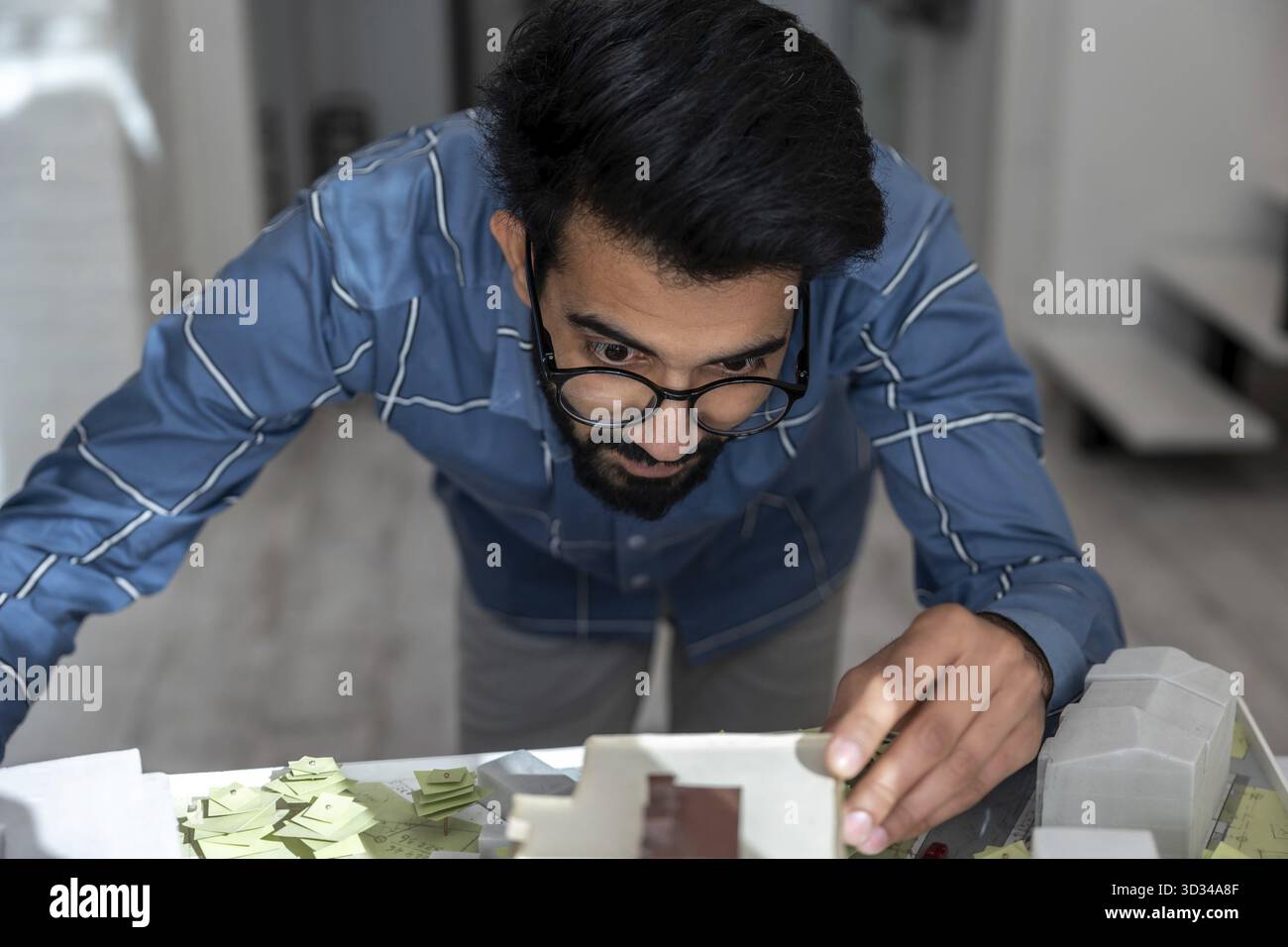 House mock up. Young engineer looking busy and involved while preparing ...