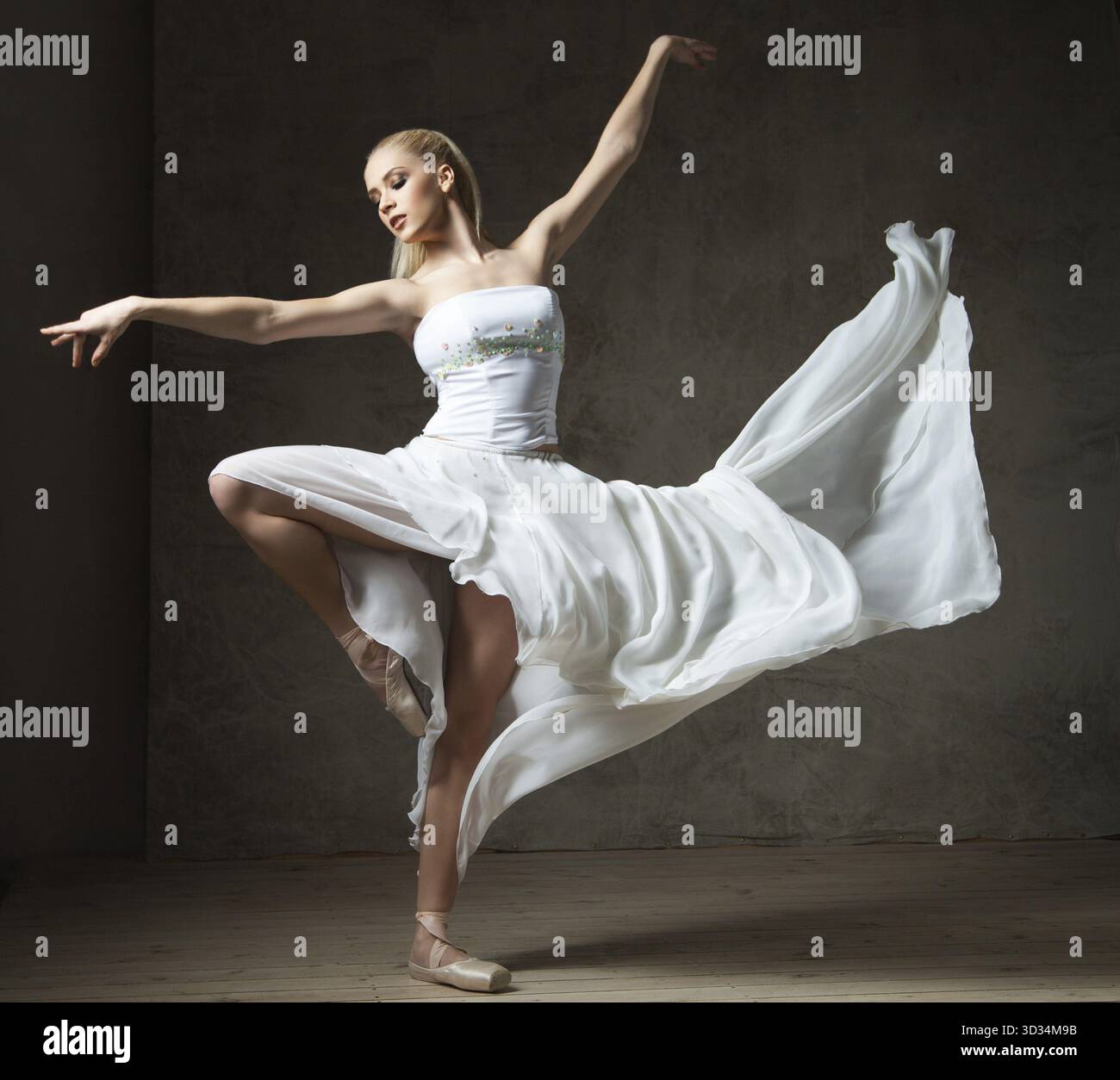 Elegant ballerina in white dancing with arms outstretched and flying ...