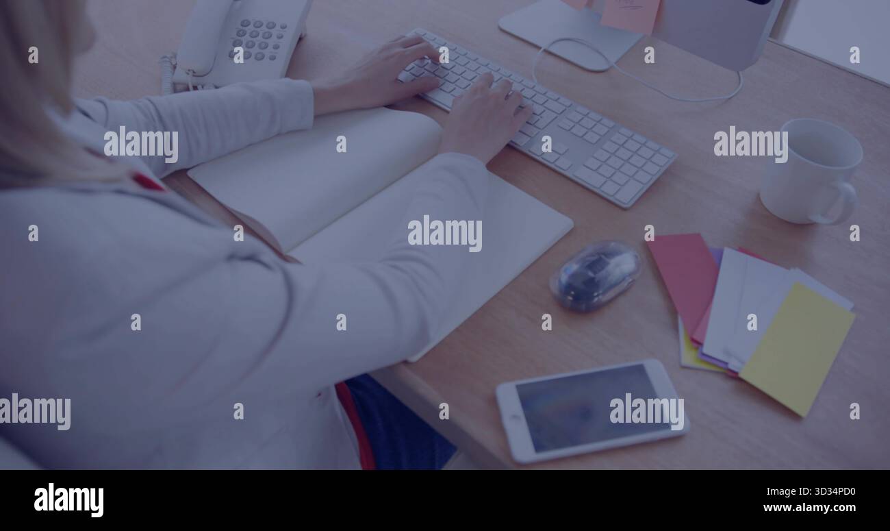 Typing woman in white blazer using wireless keyboard beside notebook at ...