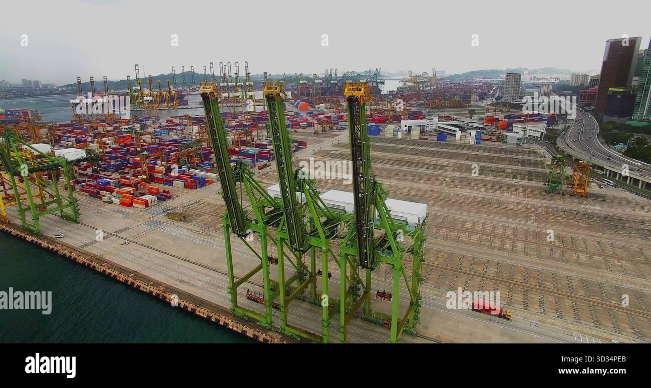 Showing three green gantry cranes lifting containers at busy seaport ...