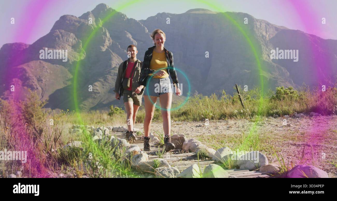 Walking couple wearing hiking boots traversing mountain trail, with ...