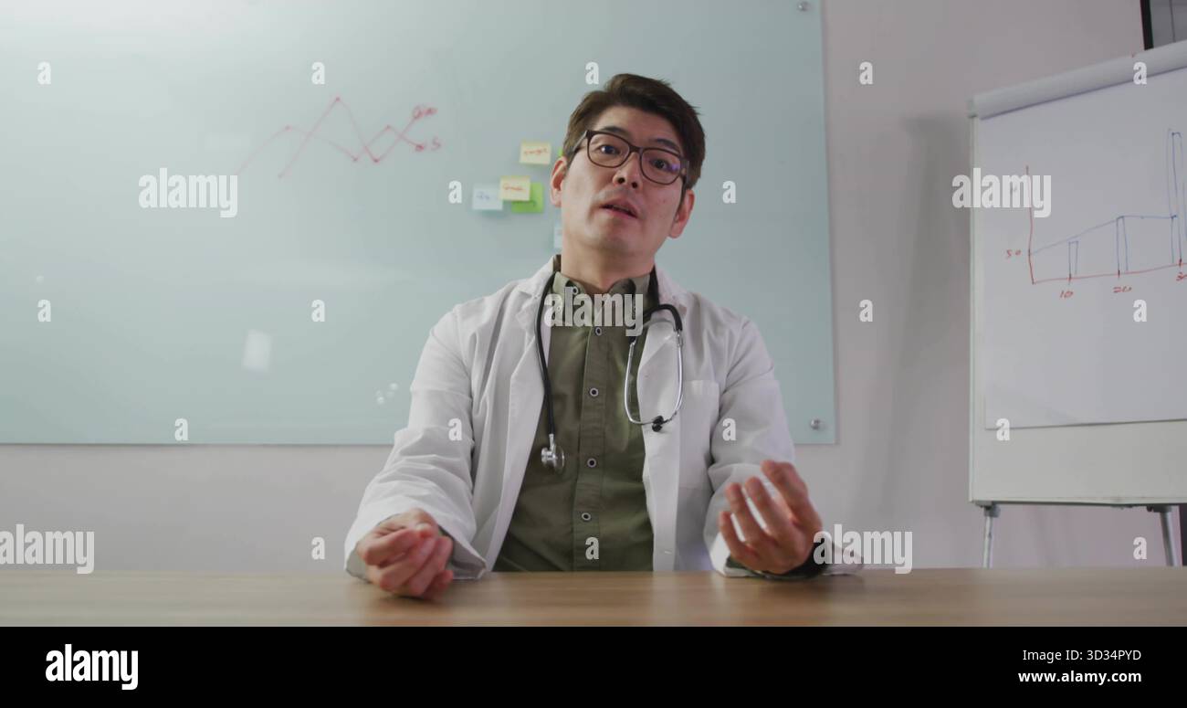 Gesturing doctor wearing white coat explaining data at clinic, with ...
