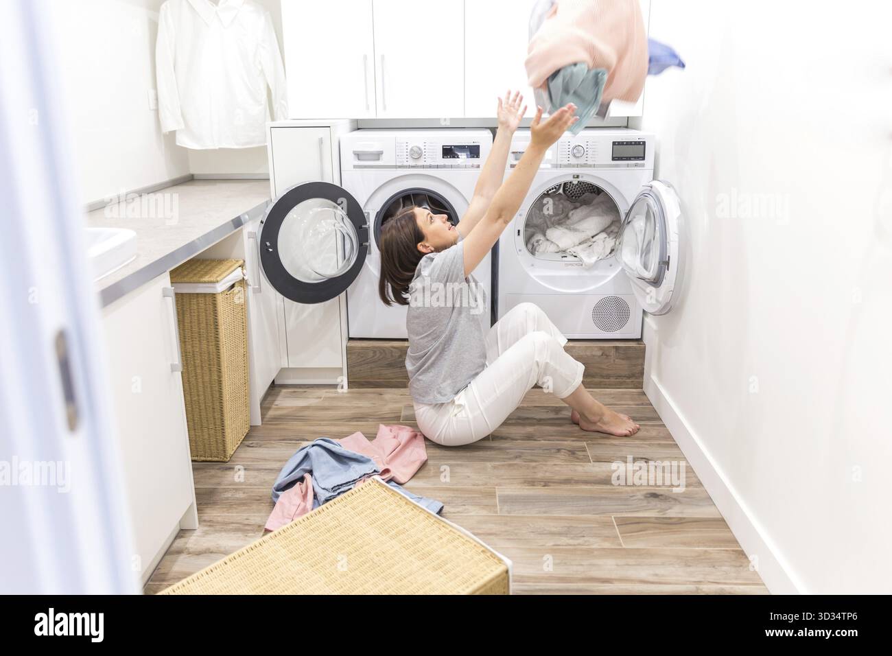 Happy family mother housewife in laundry with washing machine throwing ...