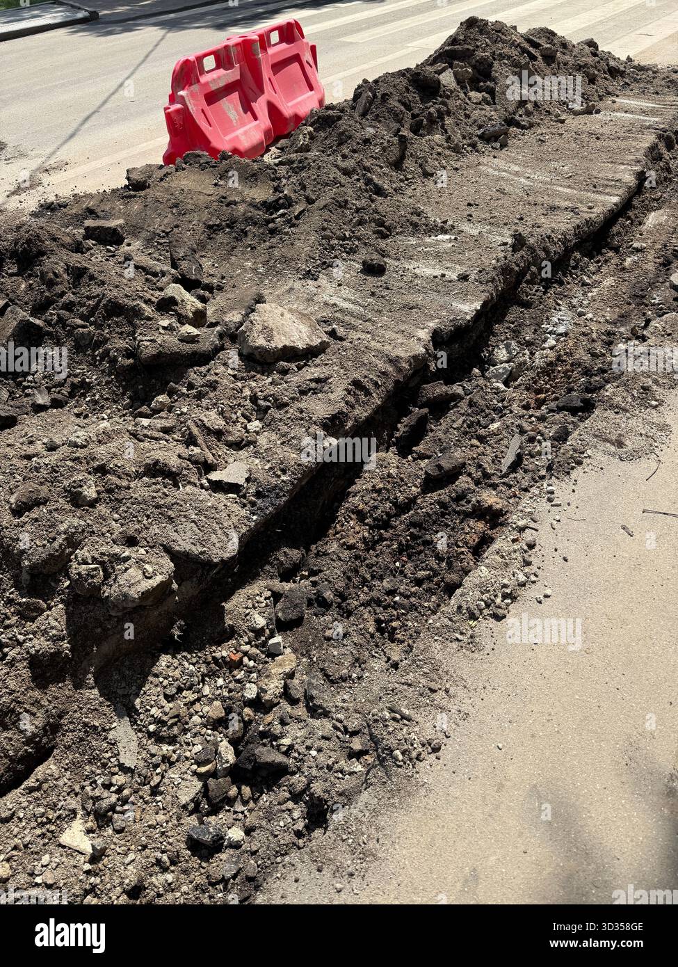 Construction site trench with soil and orange barriers, concept of ...