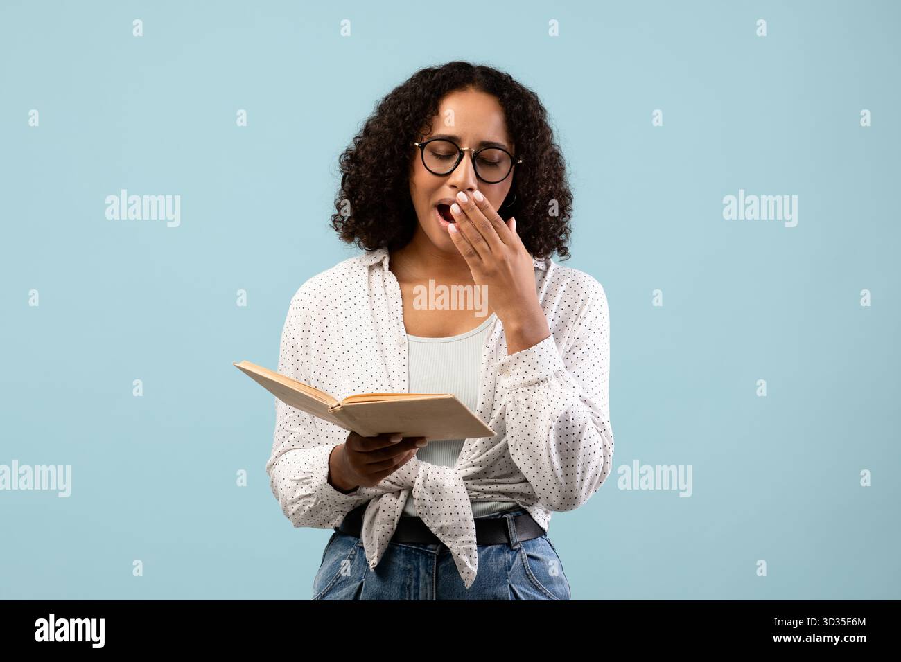 Tired african student yawning reading hi-res stock photography and ...