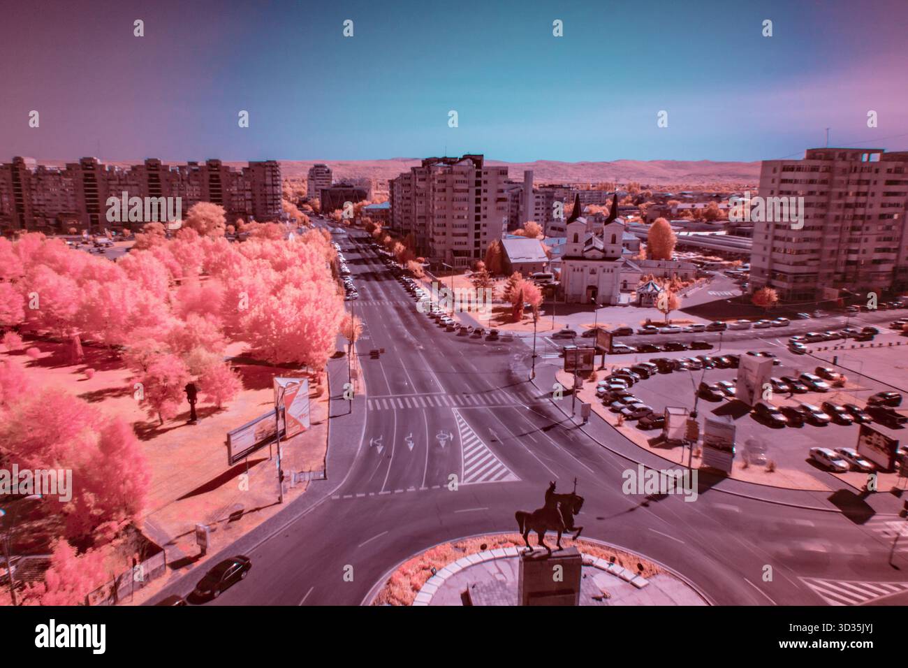 Infrared aerial view of a city intersection with pink trees, buildings ...