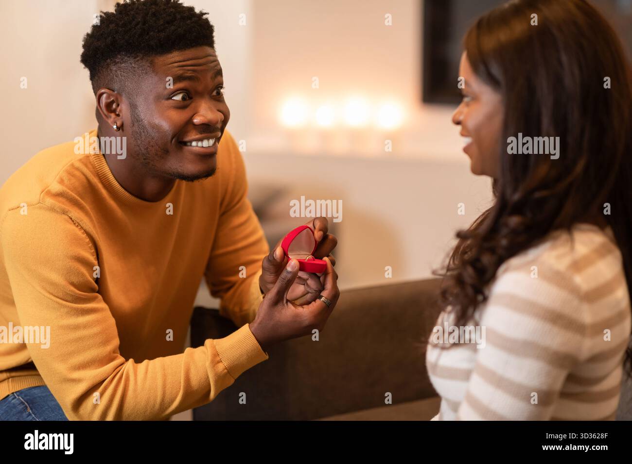Excited Black Man Proposes With Engagement Ring at Home on Cozy Couch ...