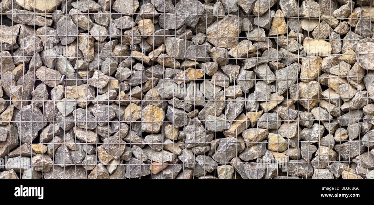 Rugged gabion wall of stones with grid pattern for construction and ...