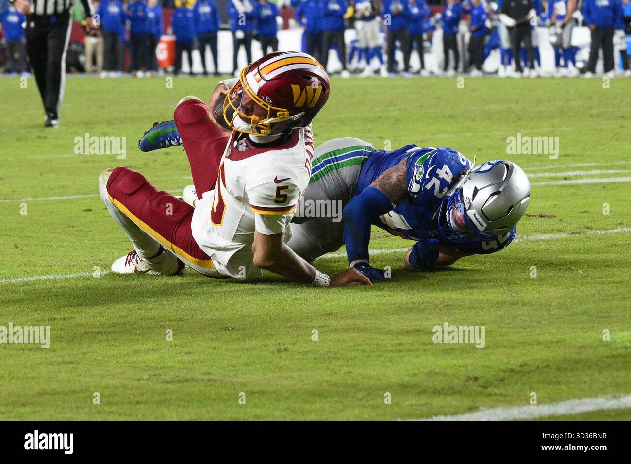 Washington Commanders quarterback Jayden Daniels (5) injures his arm as ...
