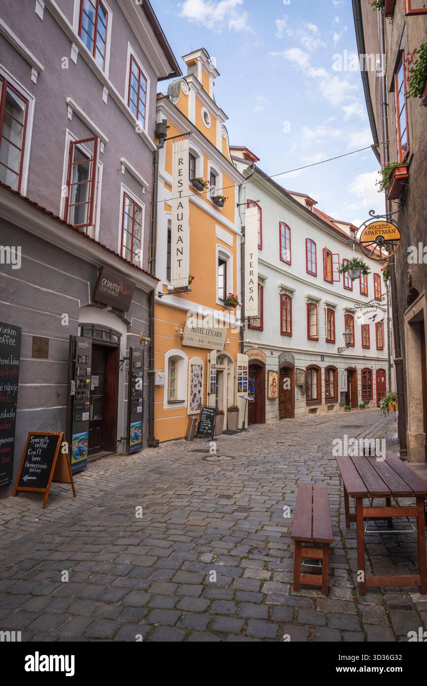 Narrow cobblestone street in medieval Český Krumlov features shops, art ...