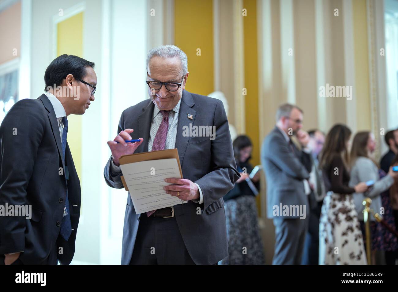 Senate Minority Leader Chuck Schumer, D-N.Y., confers with an aide ...