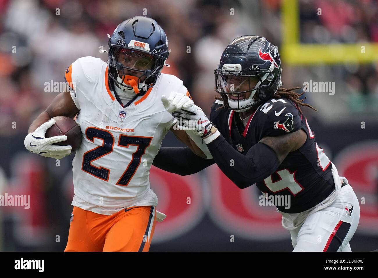 Denver Broncos running back J.K. Dobbins (27) is hit by Houston Texans ...
