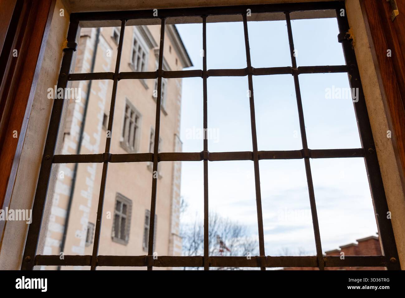 View through old metal window bars showing historic building facade and ...