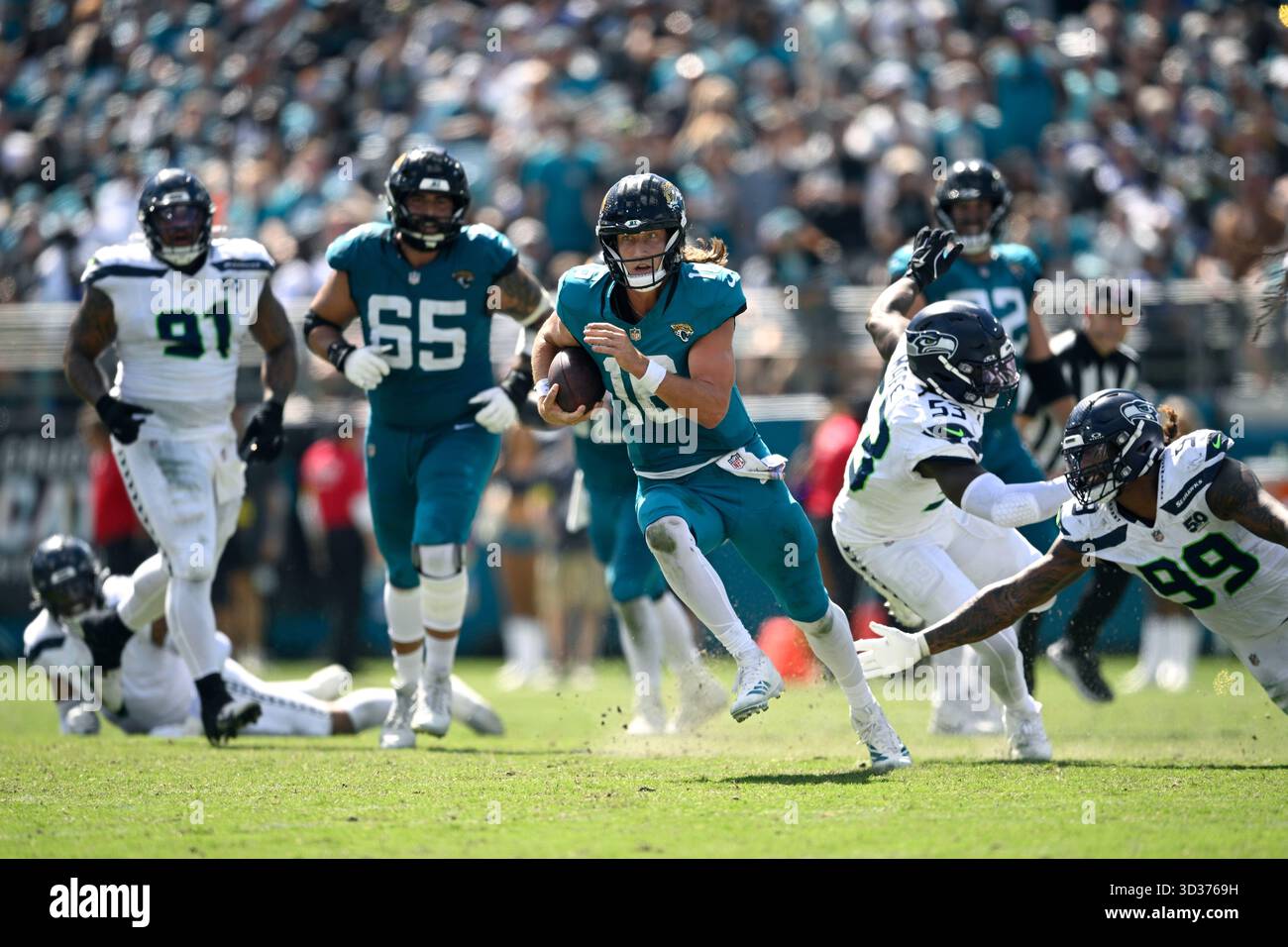 Jacksonville Jaguars quarterback Trevor Lawrence (16) is tripped up by ...
