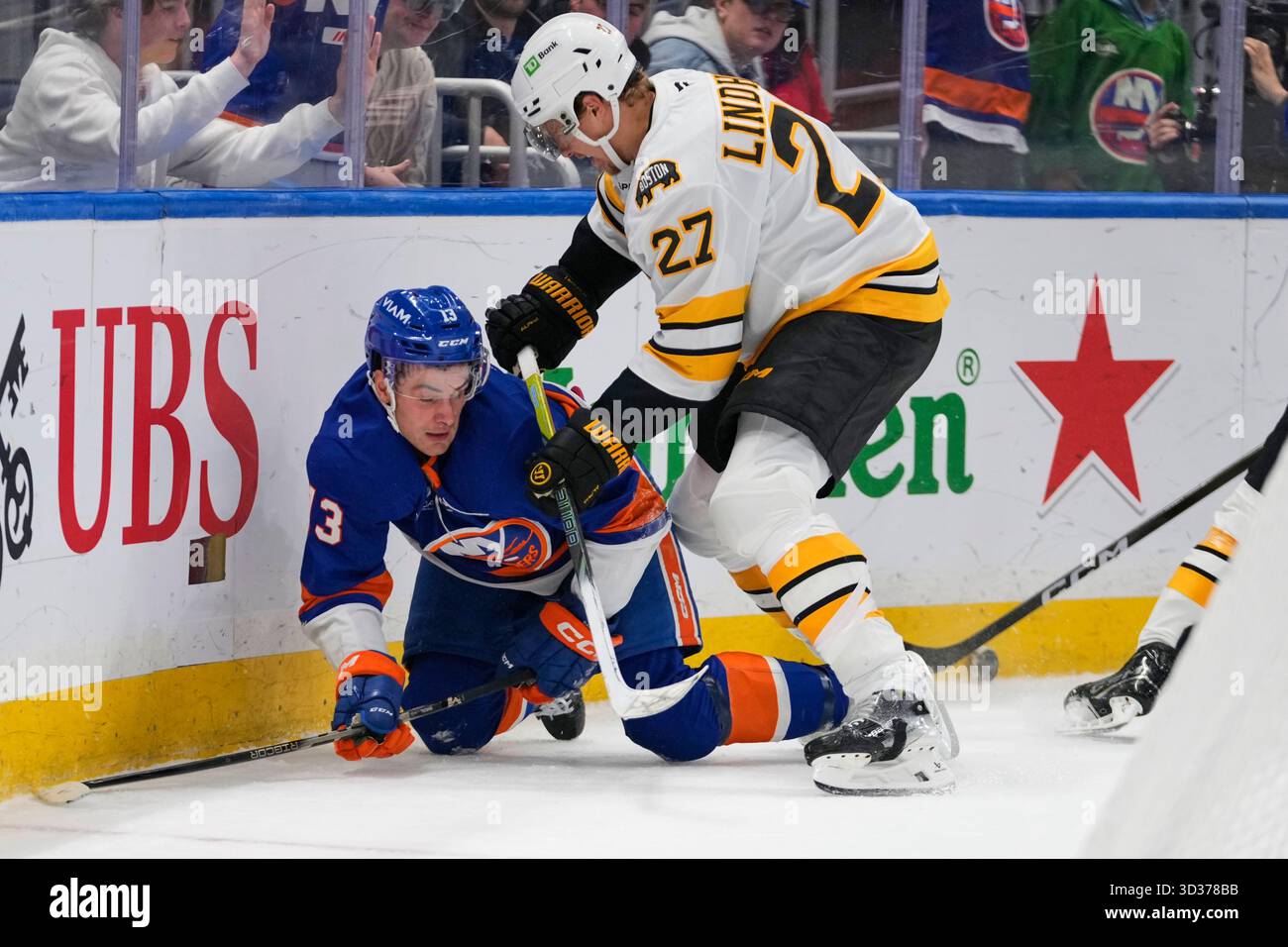 Boston Bruins' Hampus Lindholm (27) checks New York Islanders' Mathew ...