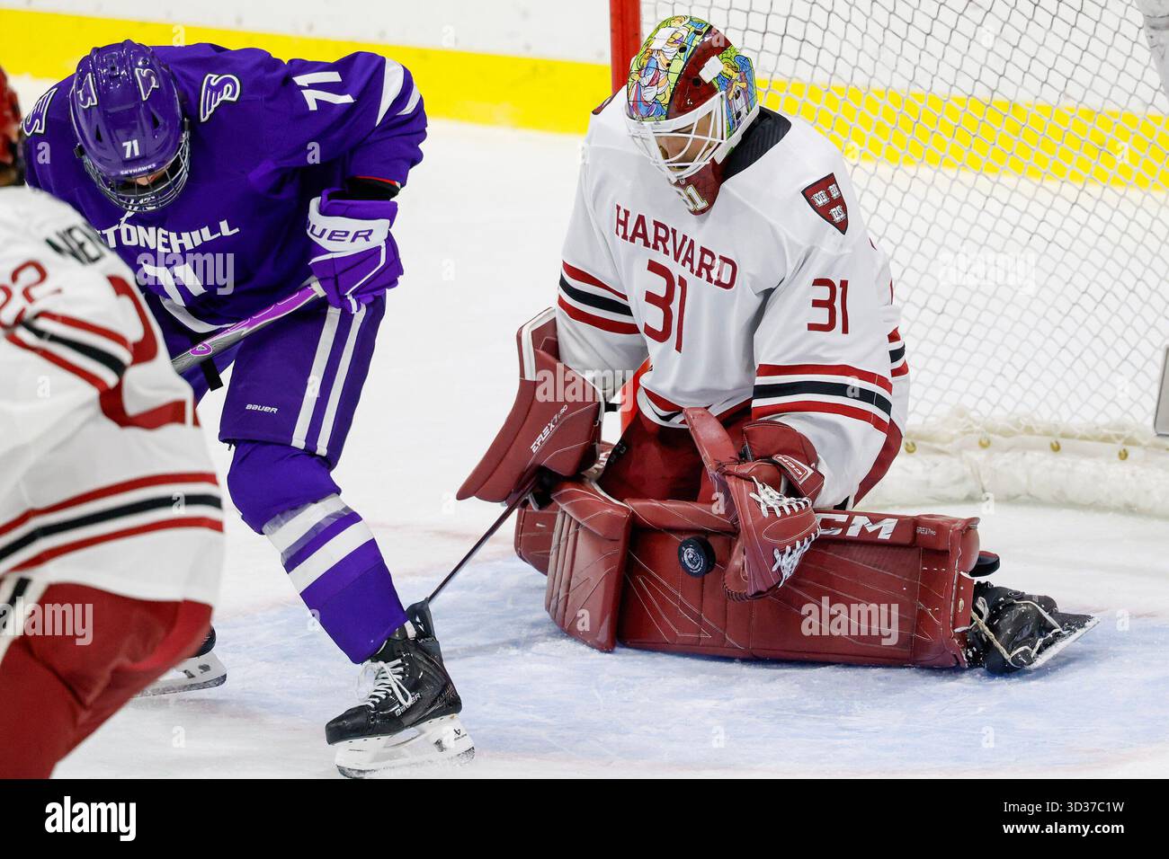 Harvard goalie Ben Charette (31) makes a save in front of Stonehill ...