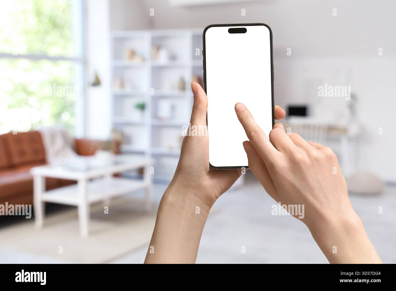 Woman holding mobile phone with blank screen in room Stock Photo - Alamy