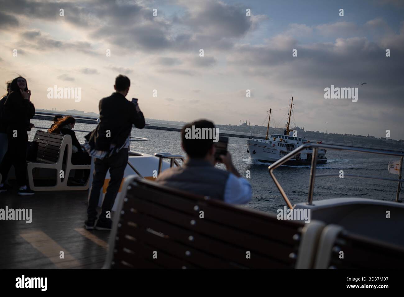 Some passengers on the terrace of a city ferry in Istanbul are seen ...